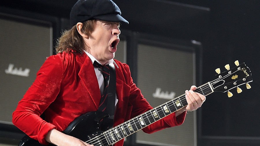AC/DC's Angus Young Explains Who Got Him to Wear Schoolboy Uniform Onstage, Clarifies if Bon ...